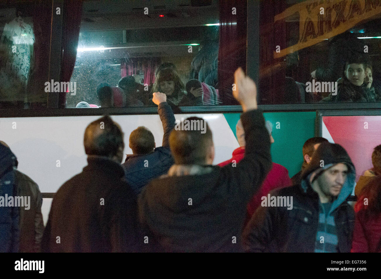 A group of people say goodbye to one of the 10 buses loaded with ...