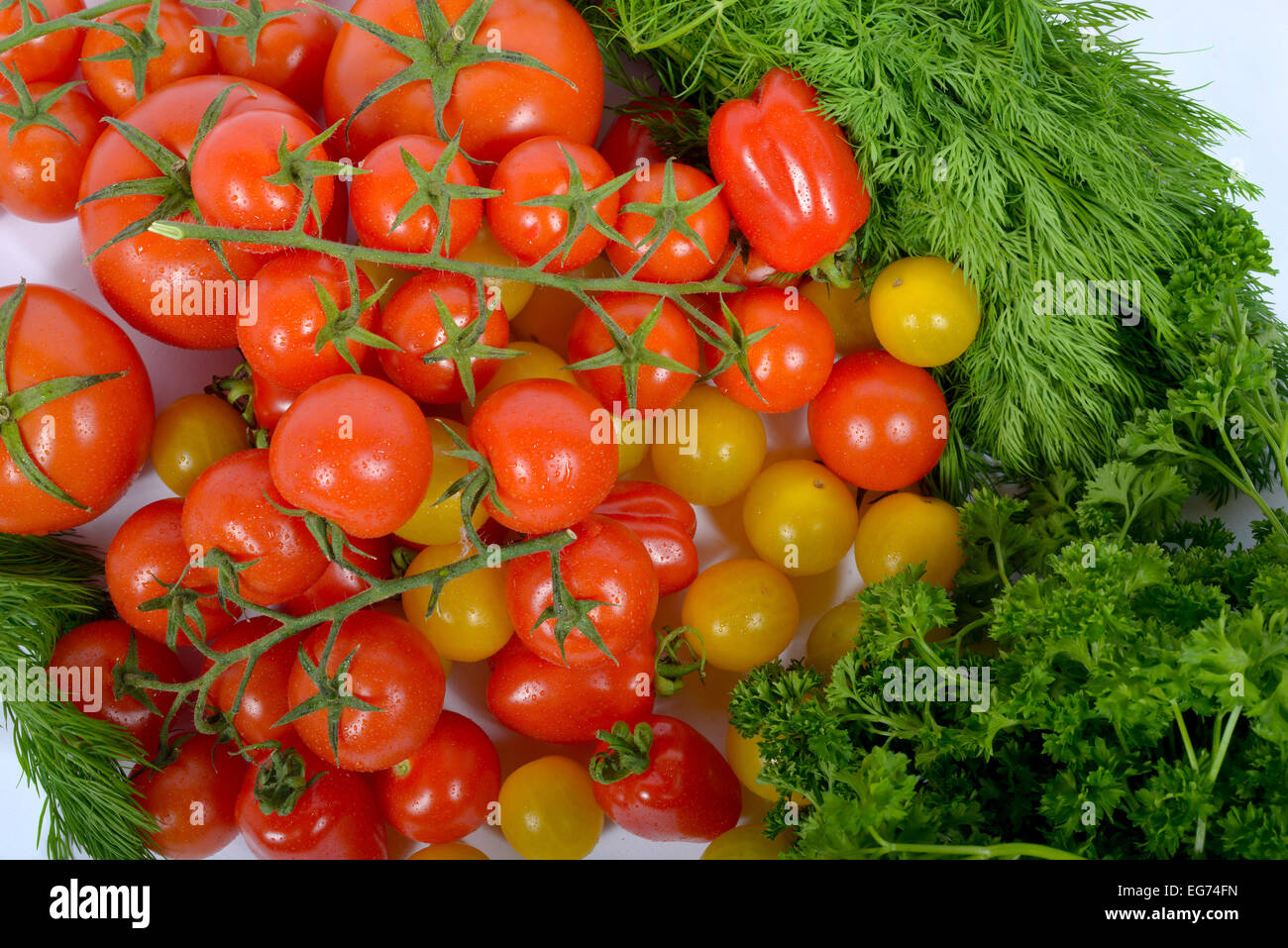 cluster of small red tomatoes with green on the white background Stock ...