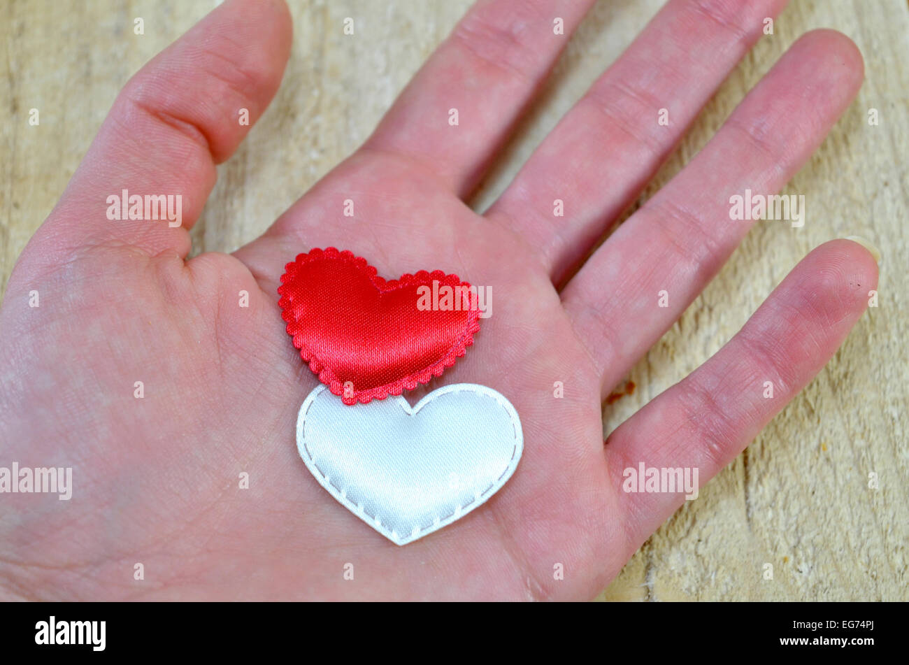 Human hand holding a white and a red heart Stock Photo - Alamy
