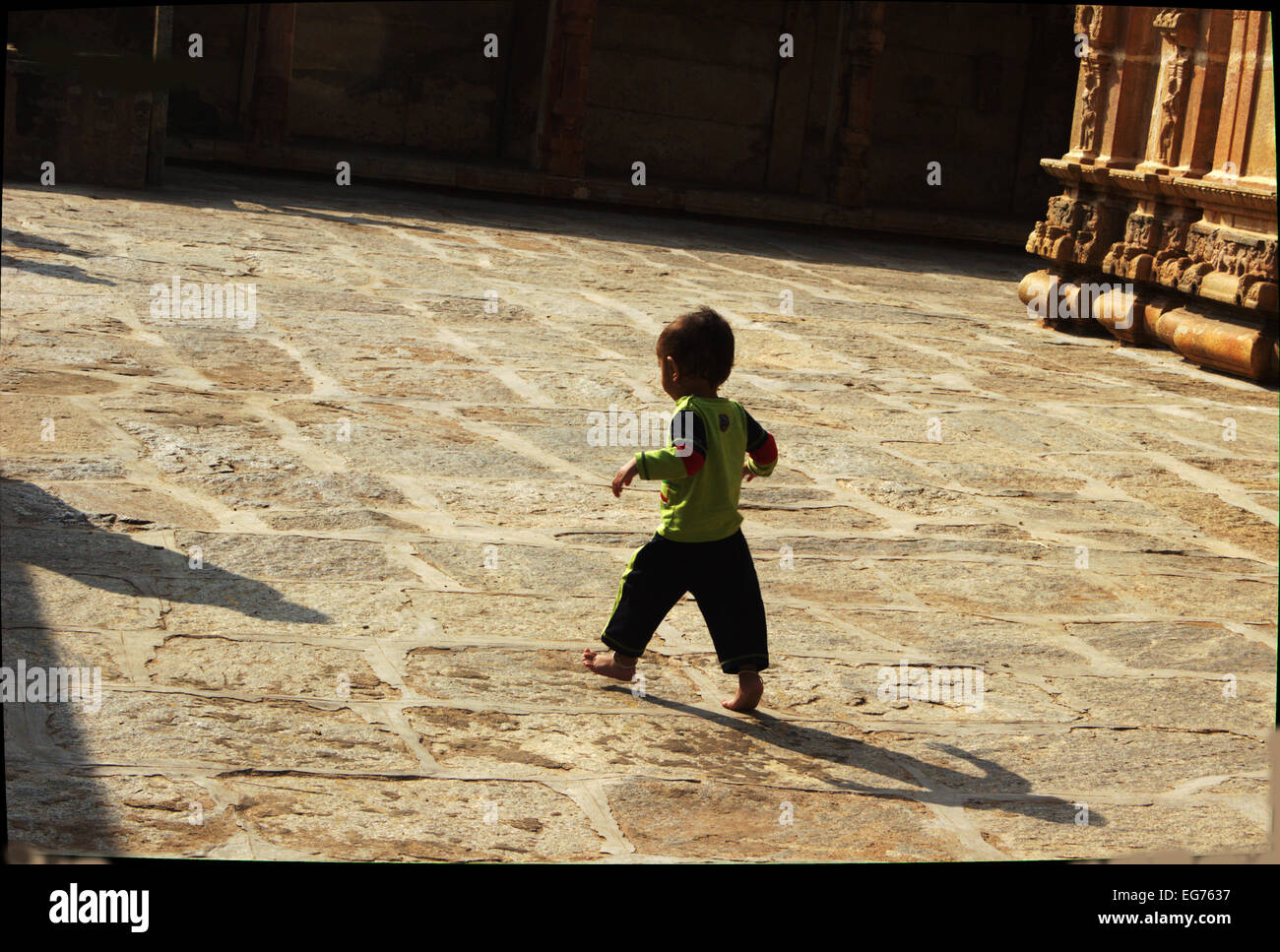 Lonely kid running on clean, sunny, stone pavement Stock Photo - Alamy