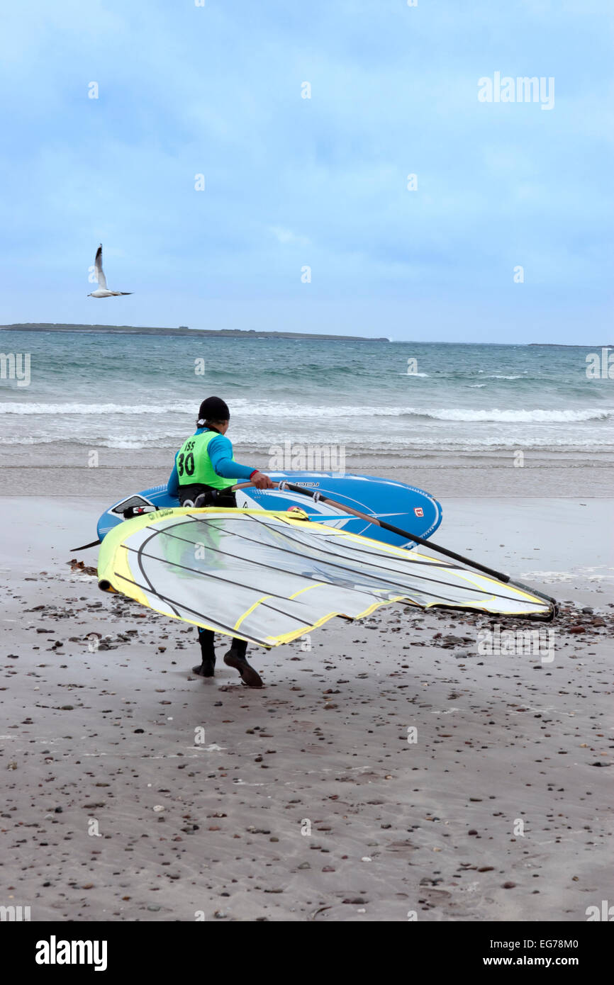 windsurfer getting ready to surf on the beach in the maharees county ...