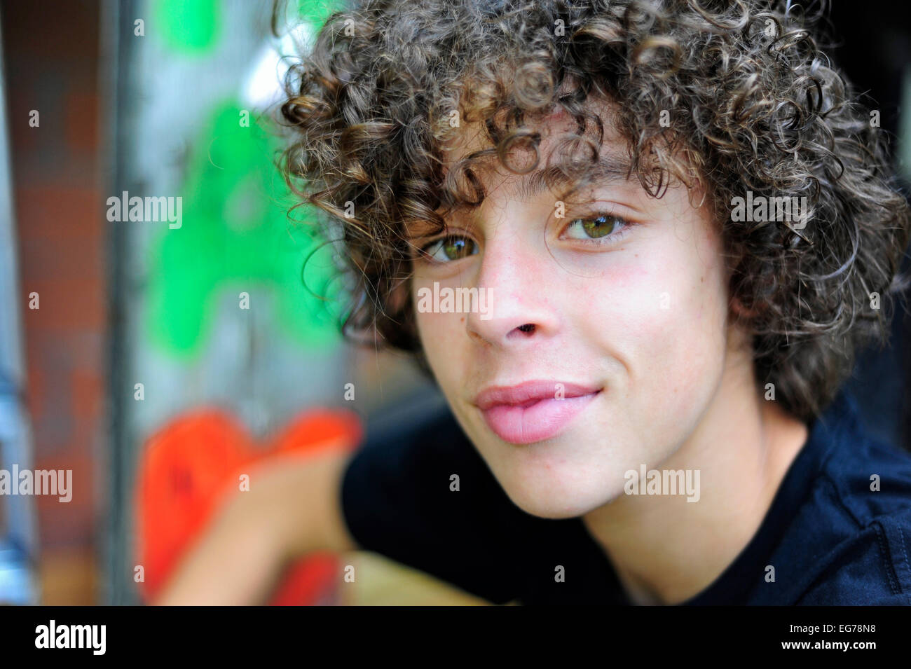 Portrait of a smiling teenage boy with brown ringlets Stock Photo - Alamy