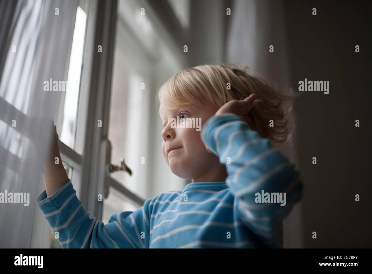 Little boy looking out of window waiting Stock Photo - Alamy