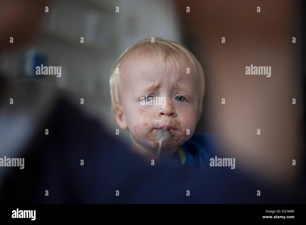 Portrait of unhappy little boy trying to eat Stock Photo - Alamy