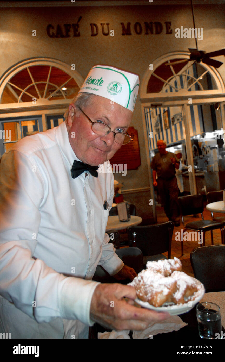 Waiter serving beignets at Cafe Du Monde in the French Quarter, New ...