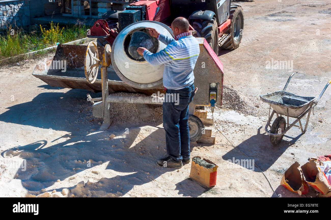 Worker and concrete mixer. The workers in a combination of cement, sand ...