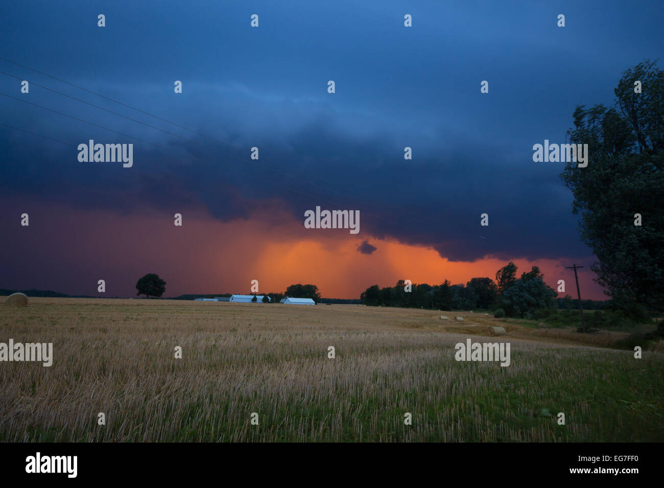 An evening thunderstorm squall line and shelf cloud are backlit by the ...