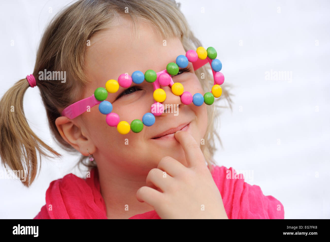 Portrait of cute little girl wearing funny glasses, decorated with ...