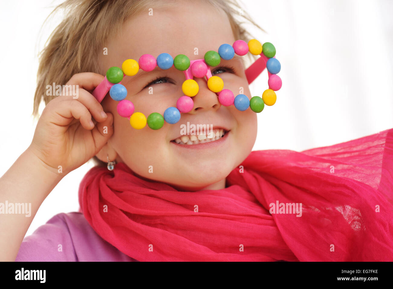 Portrait of cute little girl wearing funny glasses, decorated with ...