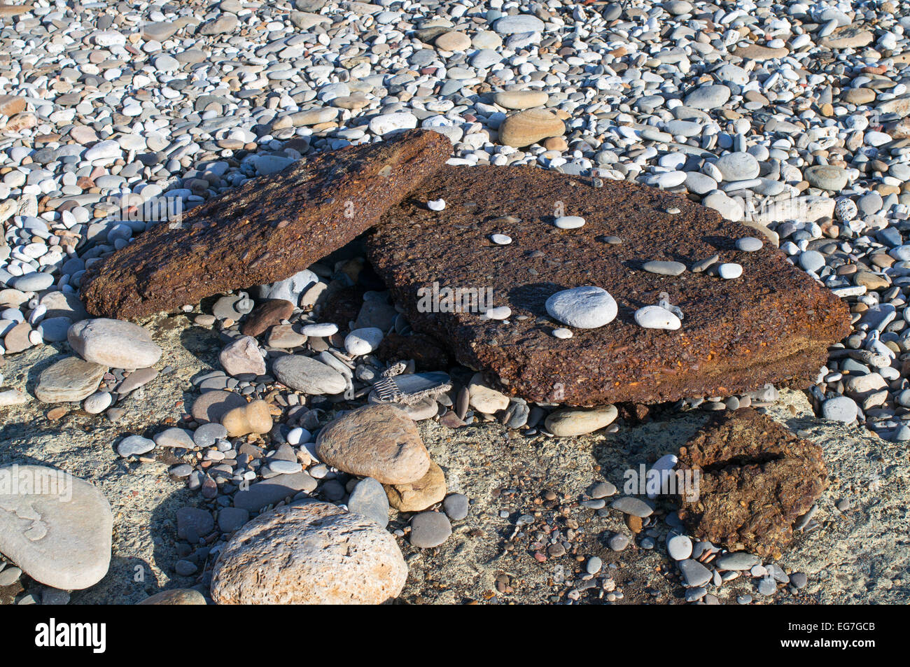 Pieces of coal mine waste, eroded by the sea, on the beach near ...