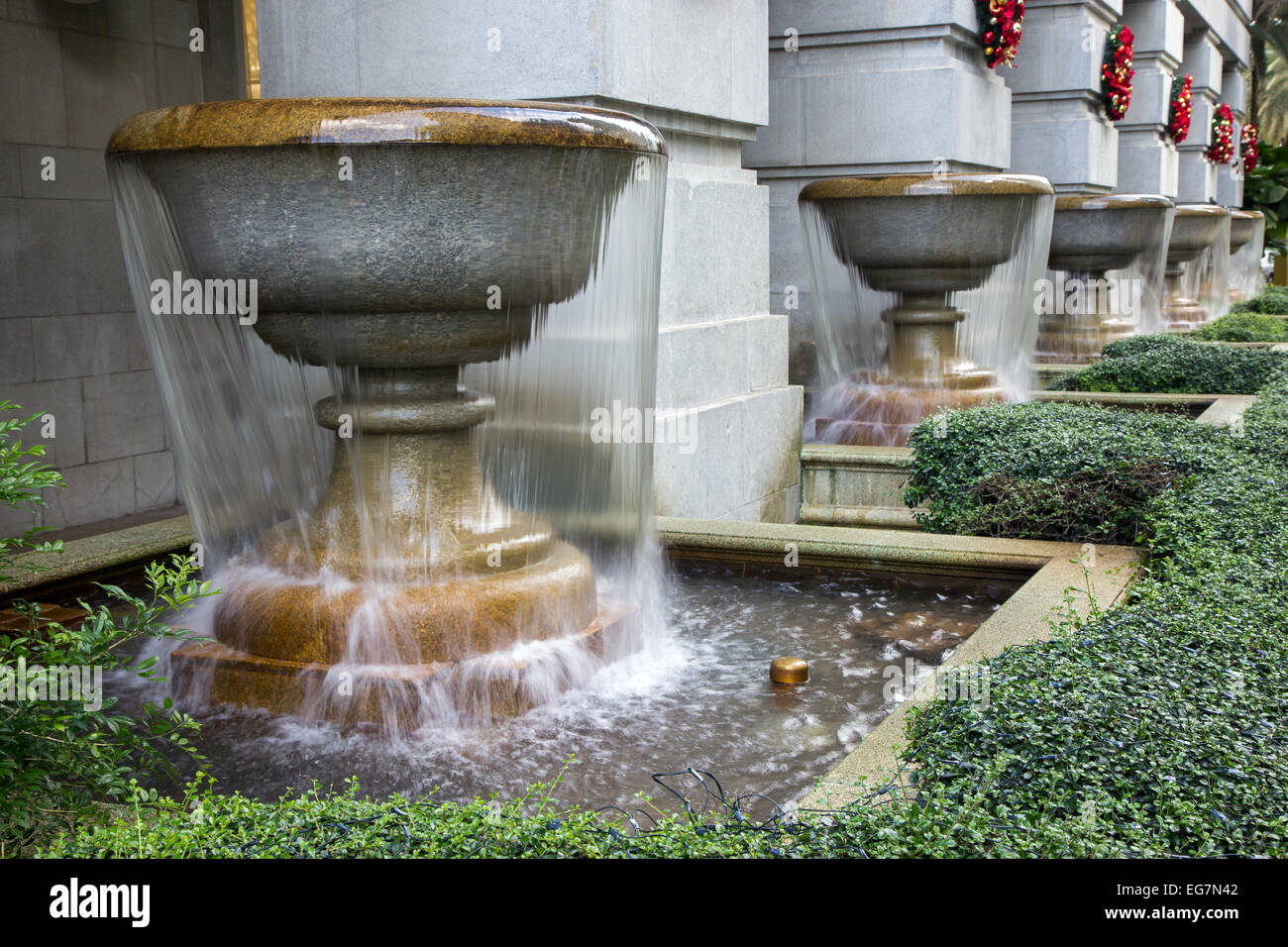 series of fountains with running water beside the arcade building Stock ...
