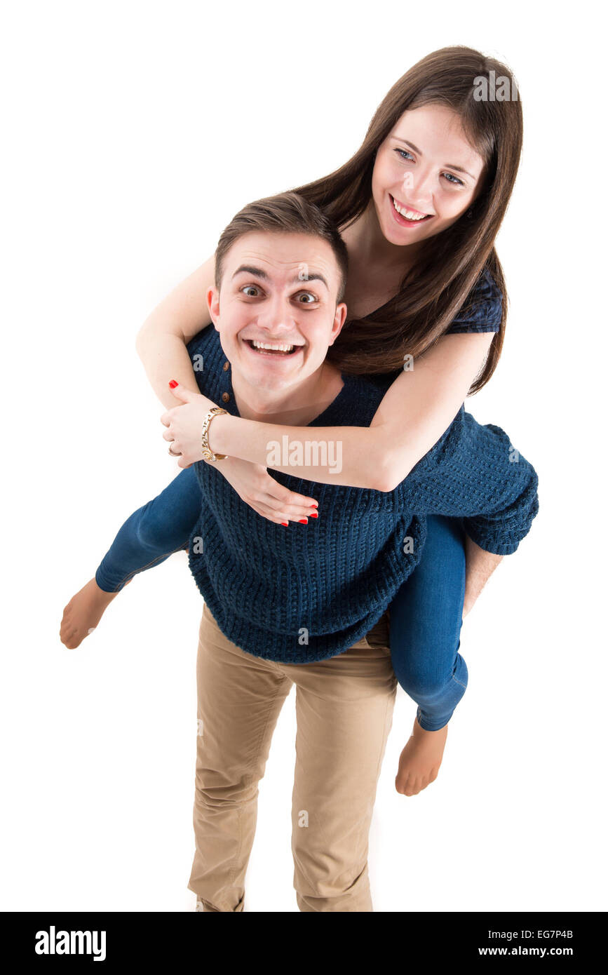 Young happy couple playing together piggyback isolated on white ...