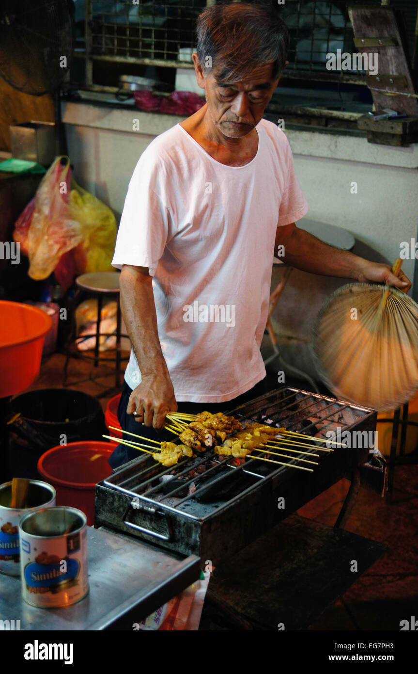 malaysian Man cooking satay chicken on a coal bbq Stock Photo - Alamy