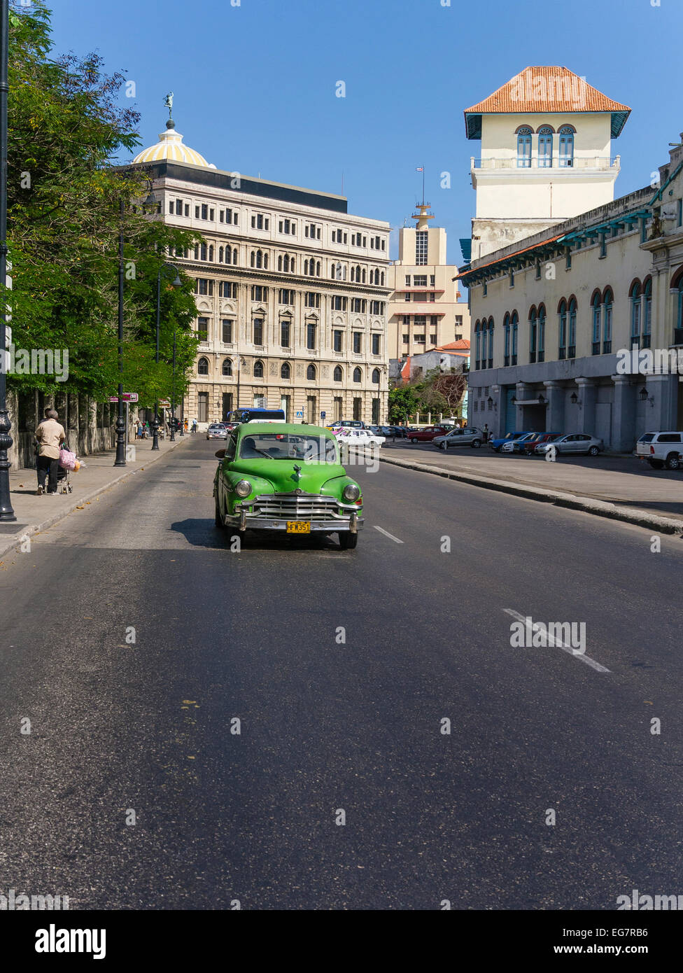 Old green car with orange license plate driving down street in Havana ...