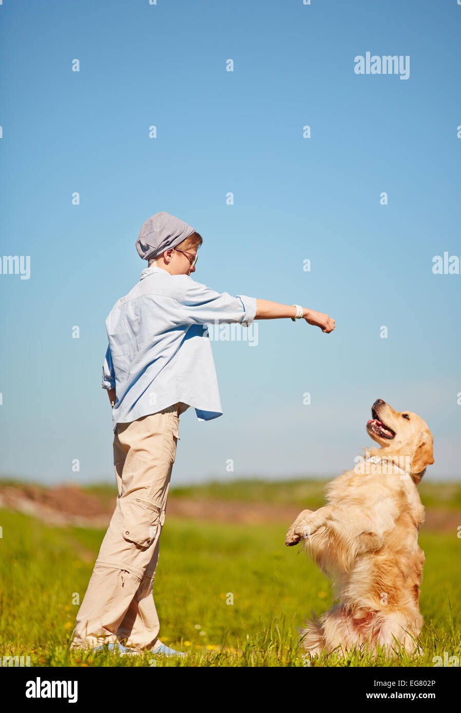 Teenage boy training his pet outdoors Stock Photo - Alamy