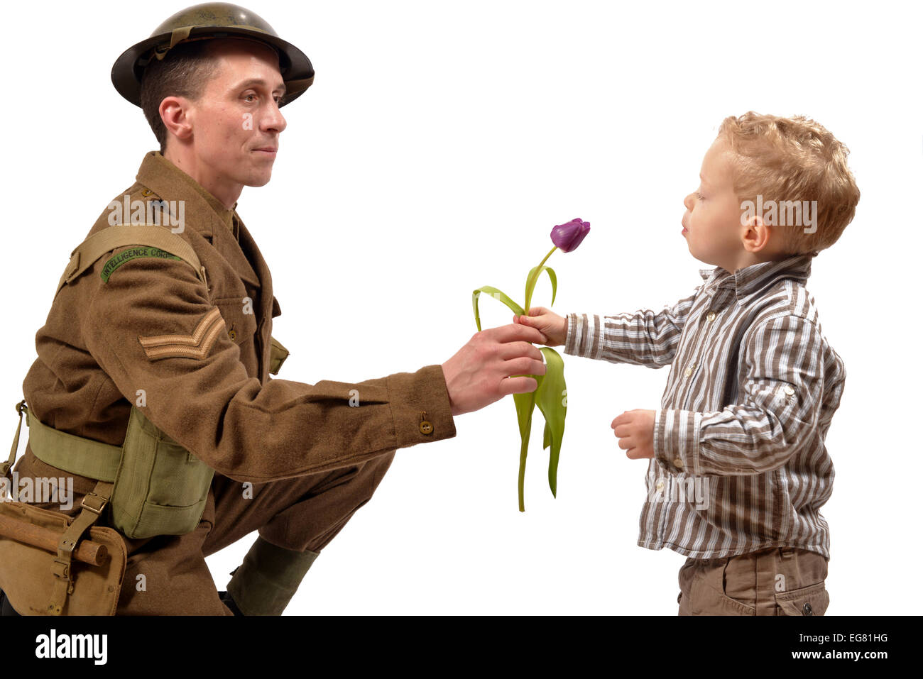 a young child gives a flower to a British soldier on the white ...