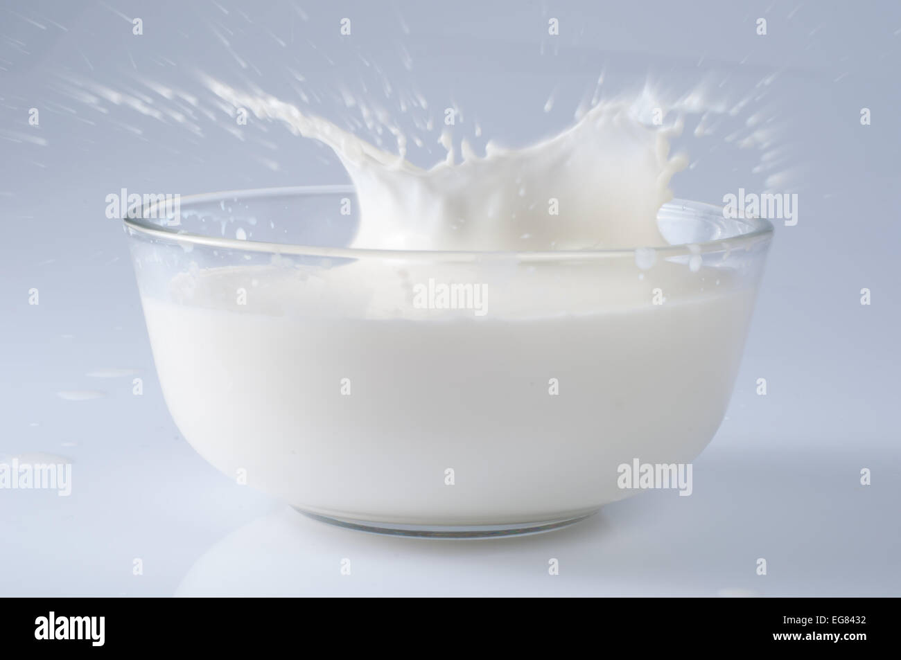pouring milk in a cup isolated against white background Stock Photo - Alamy