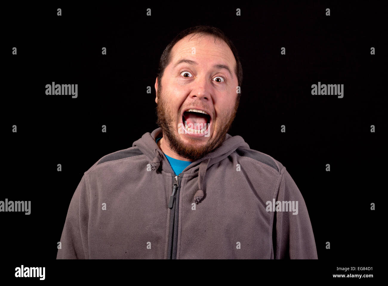 man with mouth wide open on black background Stock Photo - Alamy