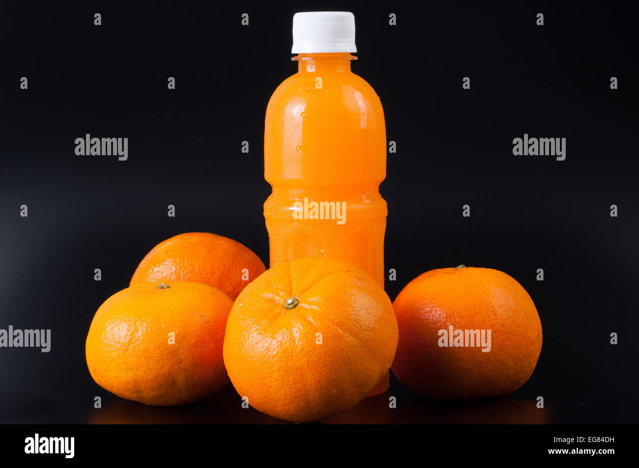 Orange juice in a bottle and orange on black background Stock Photo - Alamy