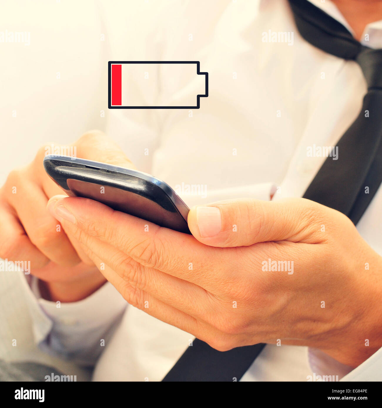 a young man using a smartphone and an illustration of a low battery ...