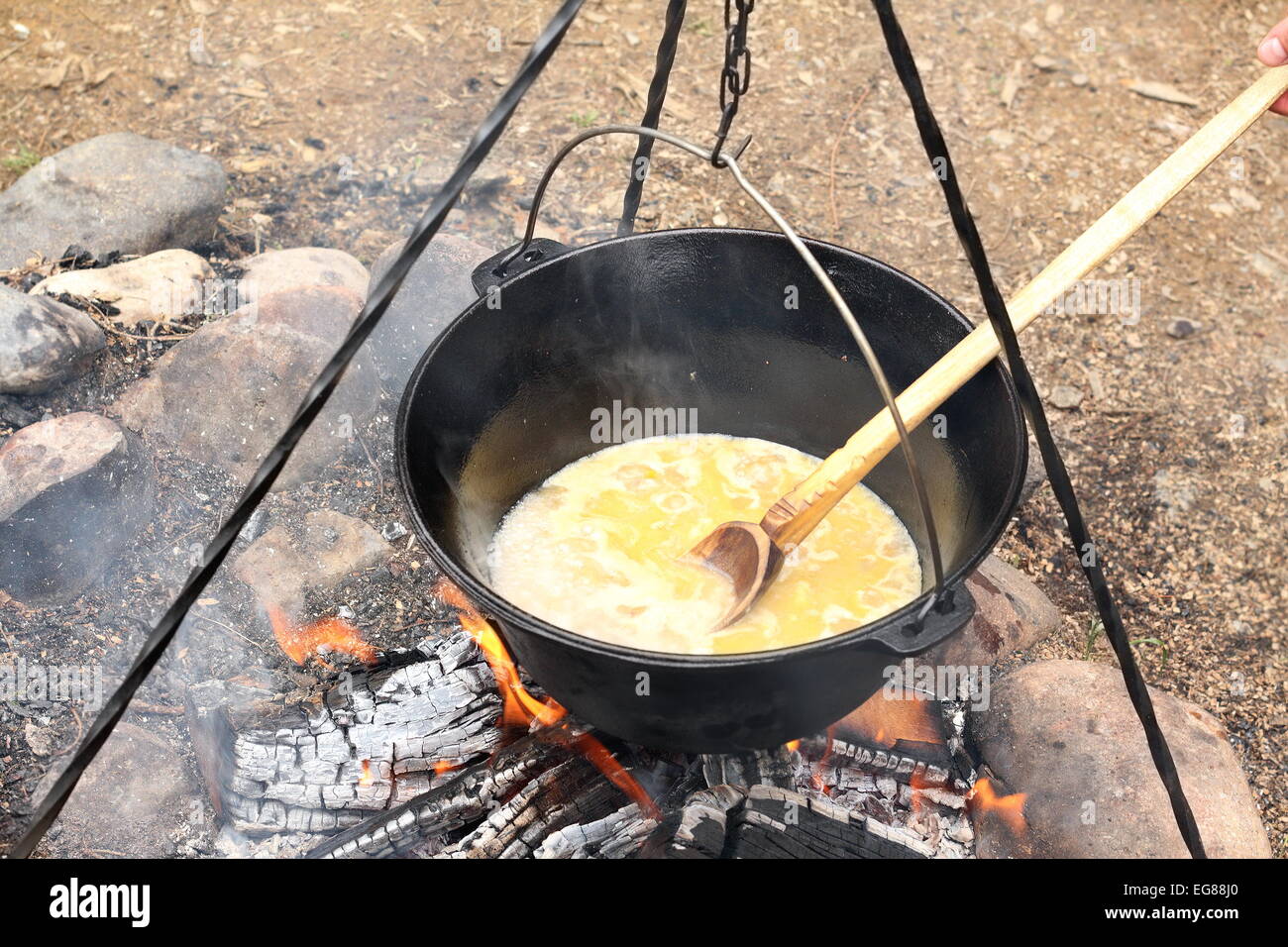 cooking in a black cauldron on camping fire, slow food Stock Photo - Alamy