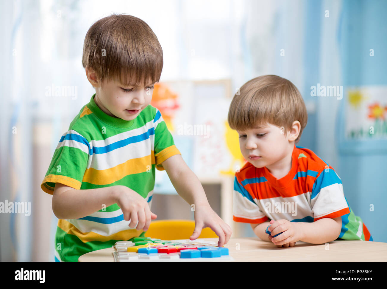 kids brothers playing together at table Stock Photo - Alamy