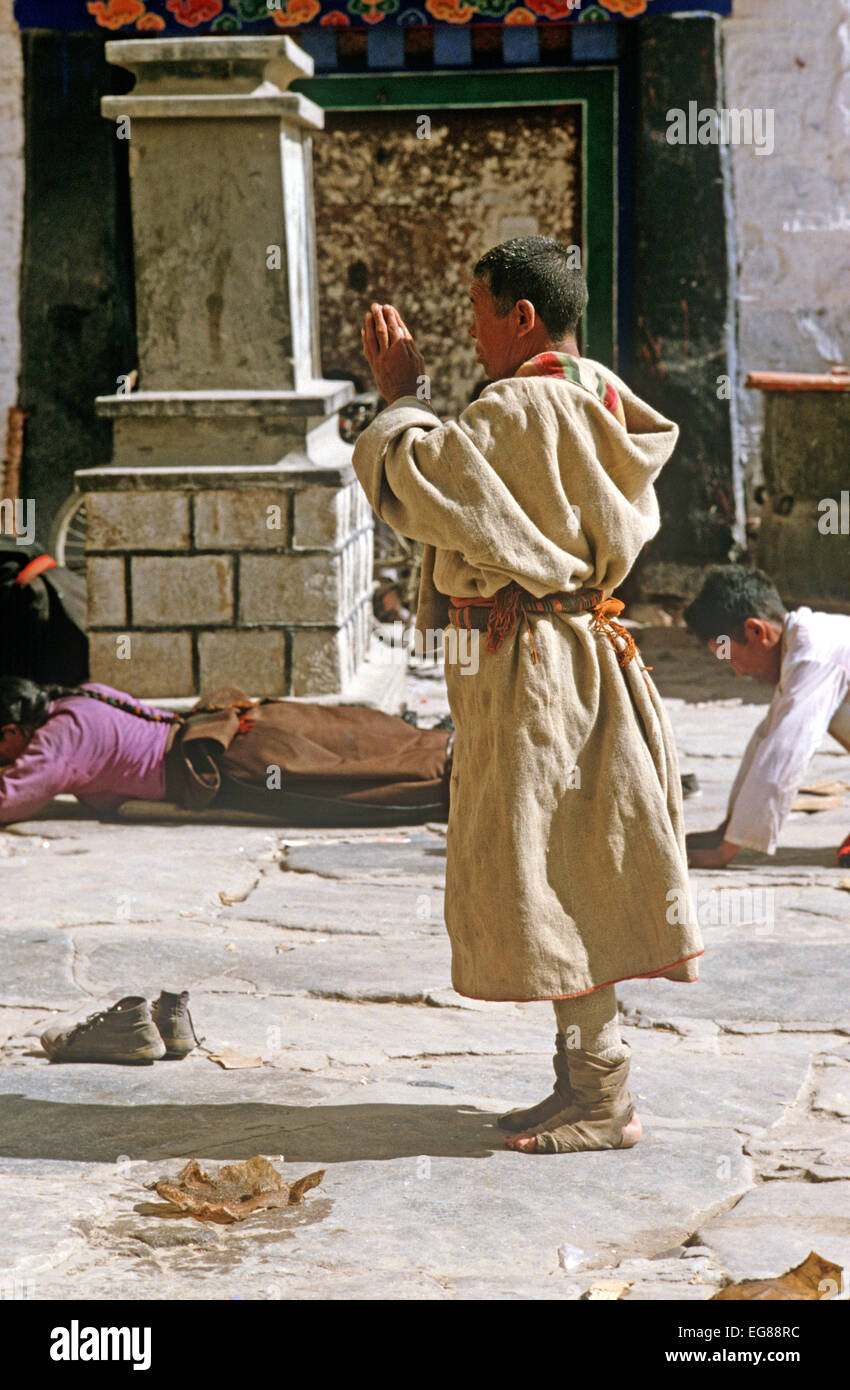 Buddhist pilgrims prostrating themselves in front of Jokhang Temple ...