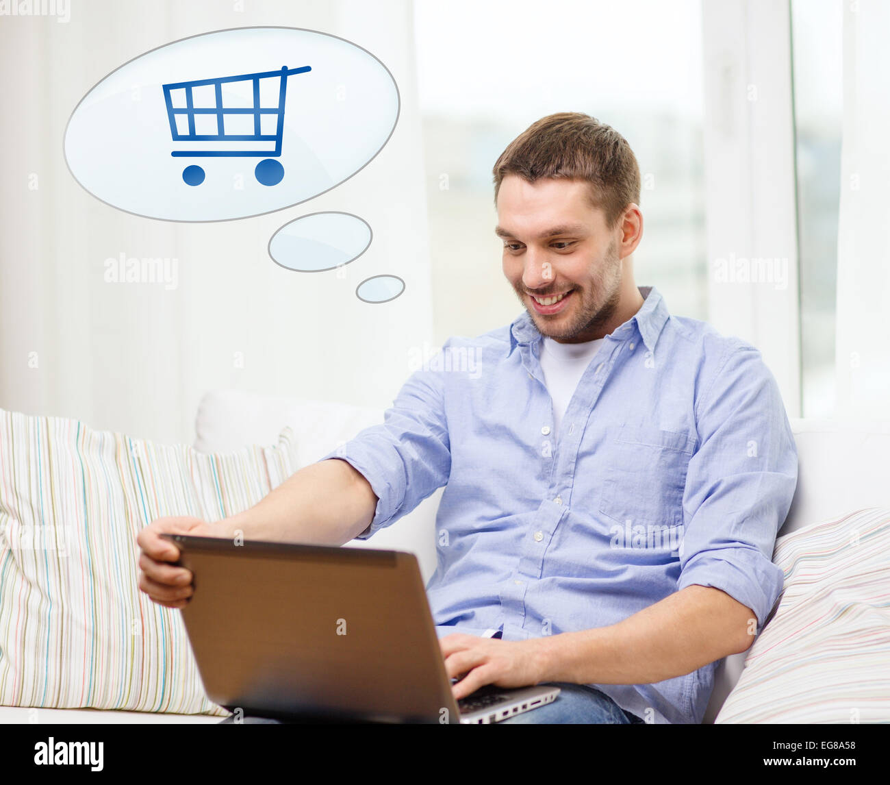smiling man with laptop shopping online at home Stock Photo - Alamy