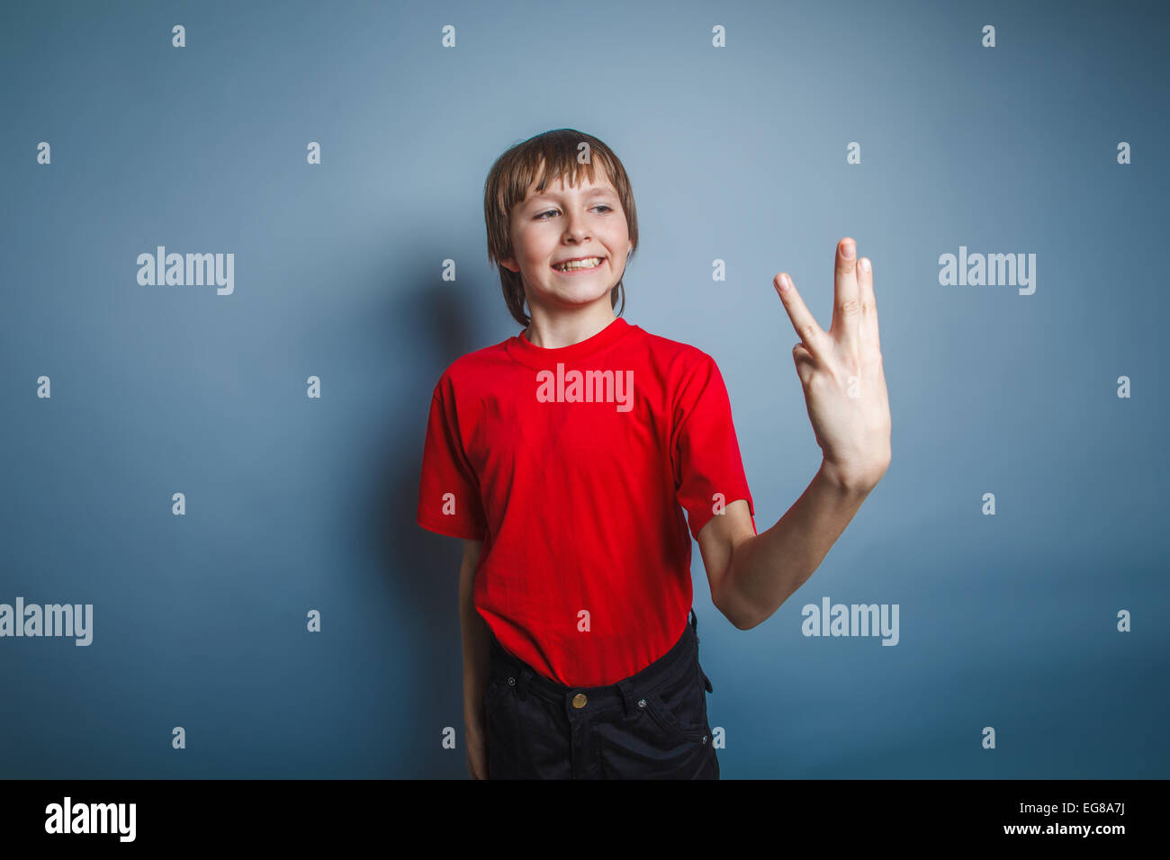 boy teenager European appearance in a red shirt showing thumbs d Stock ...