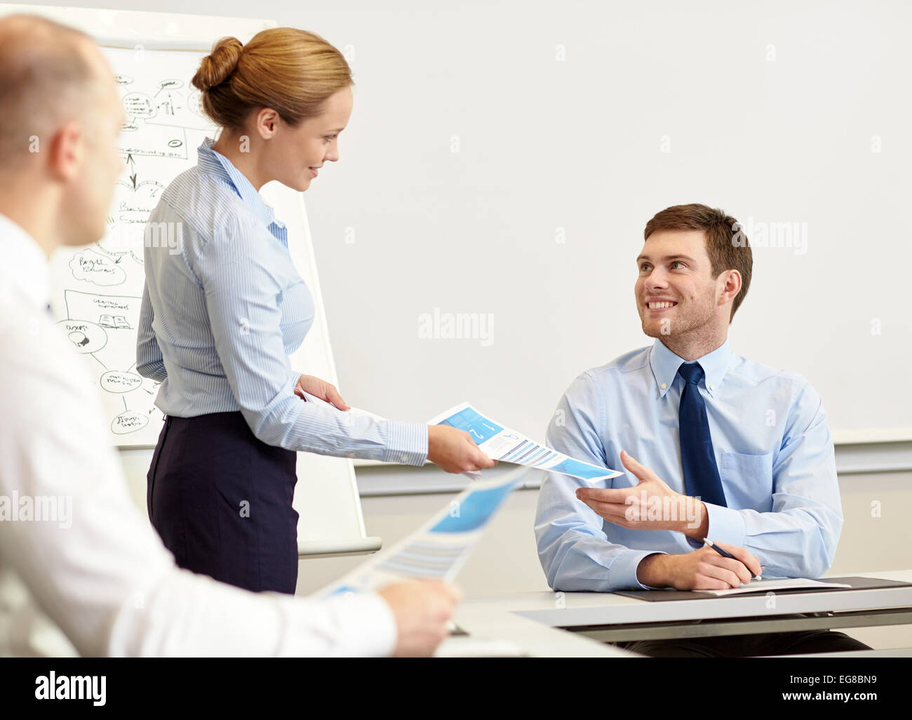 smiling woman giving papers to man in office Stock Photo - Alamy