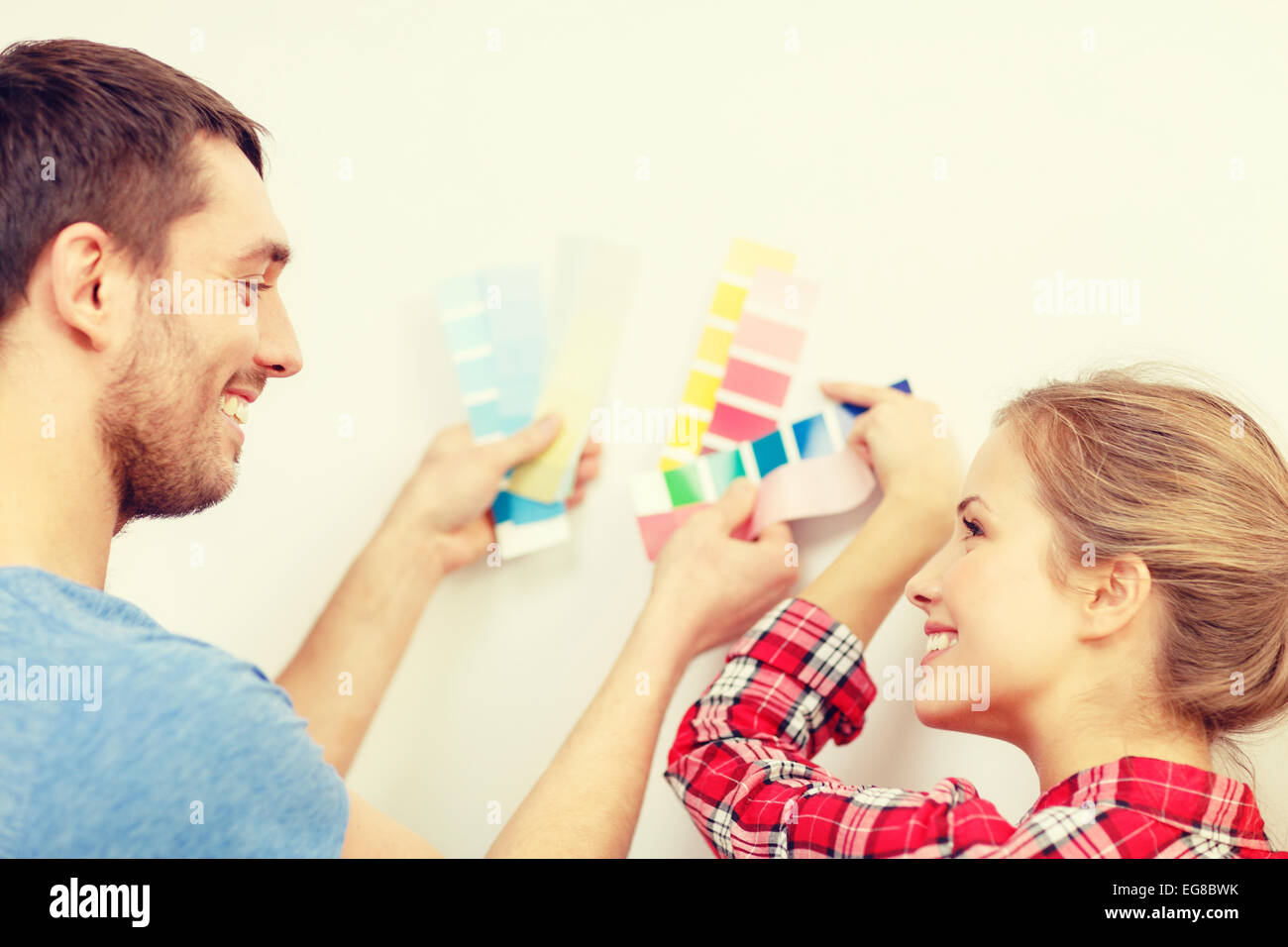 smiling couple looking at color samples at home Stock Photo - Alamy