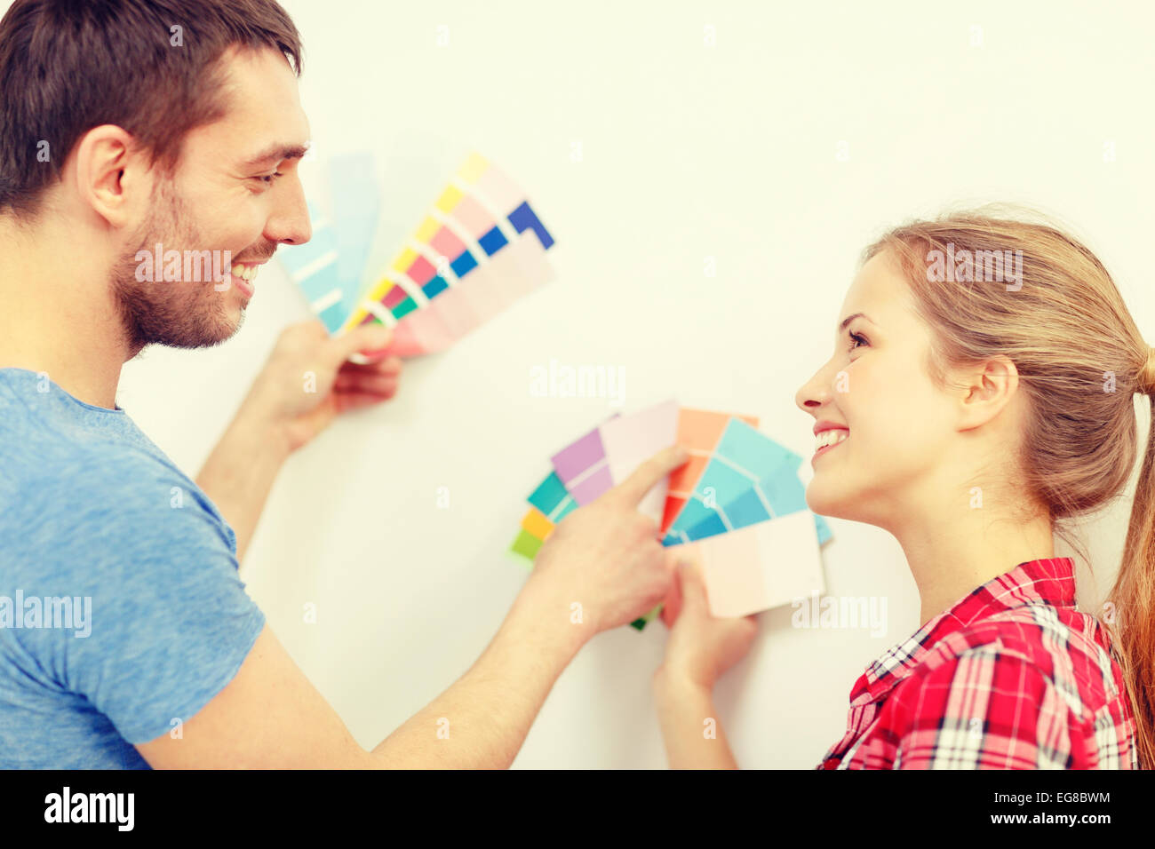 smiling couple looking at color samples at home Stock Photo - Alamy