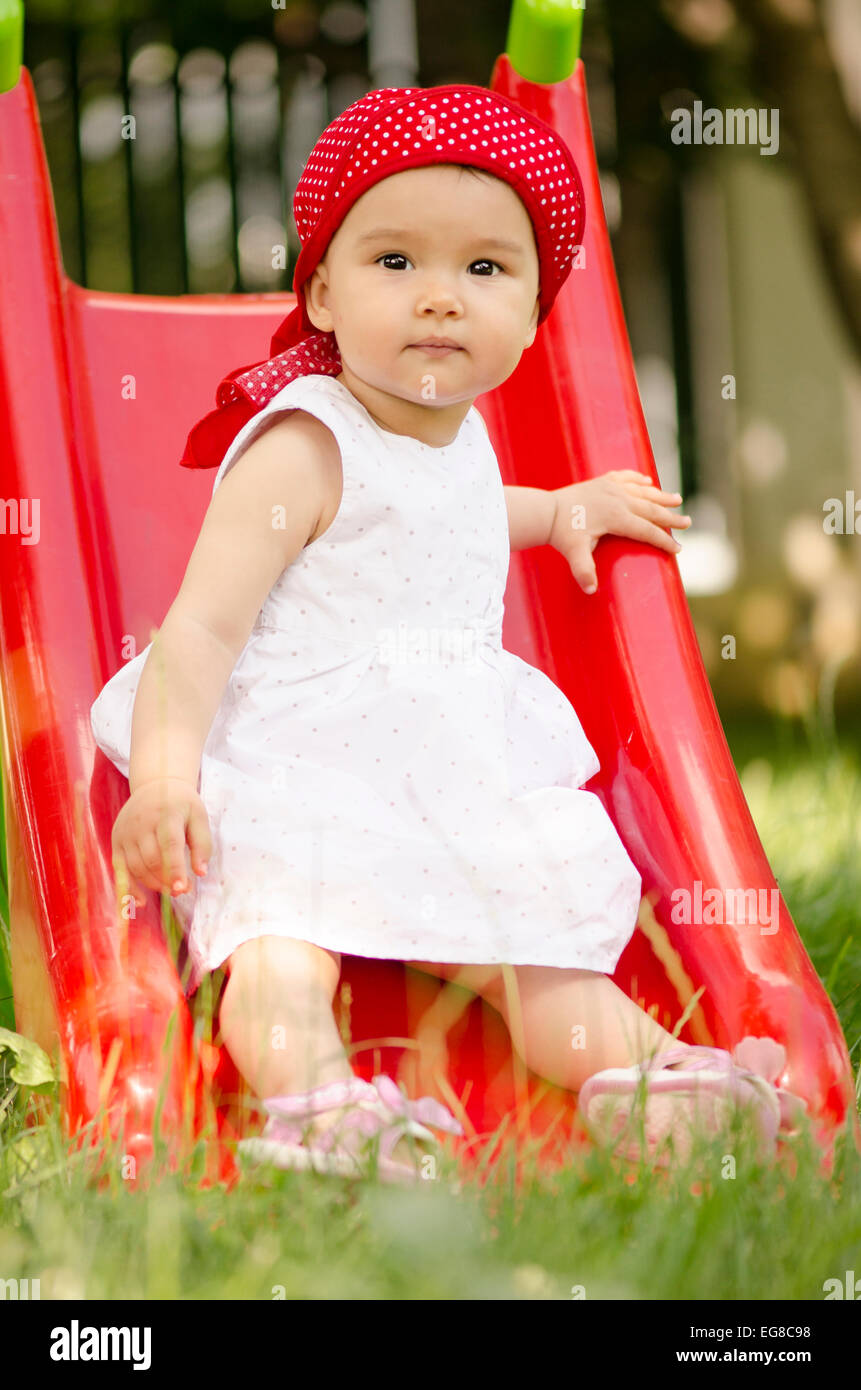 Cute baby girl playing on slide Stock Photo - Alamy