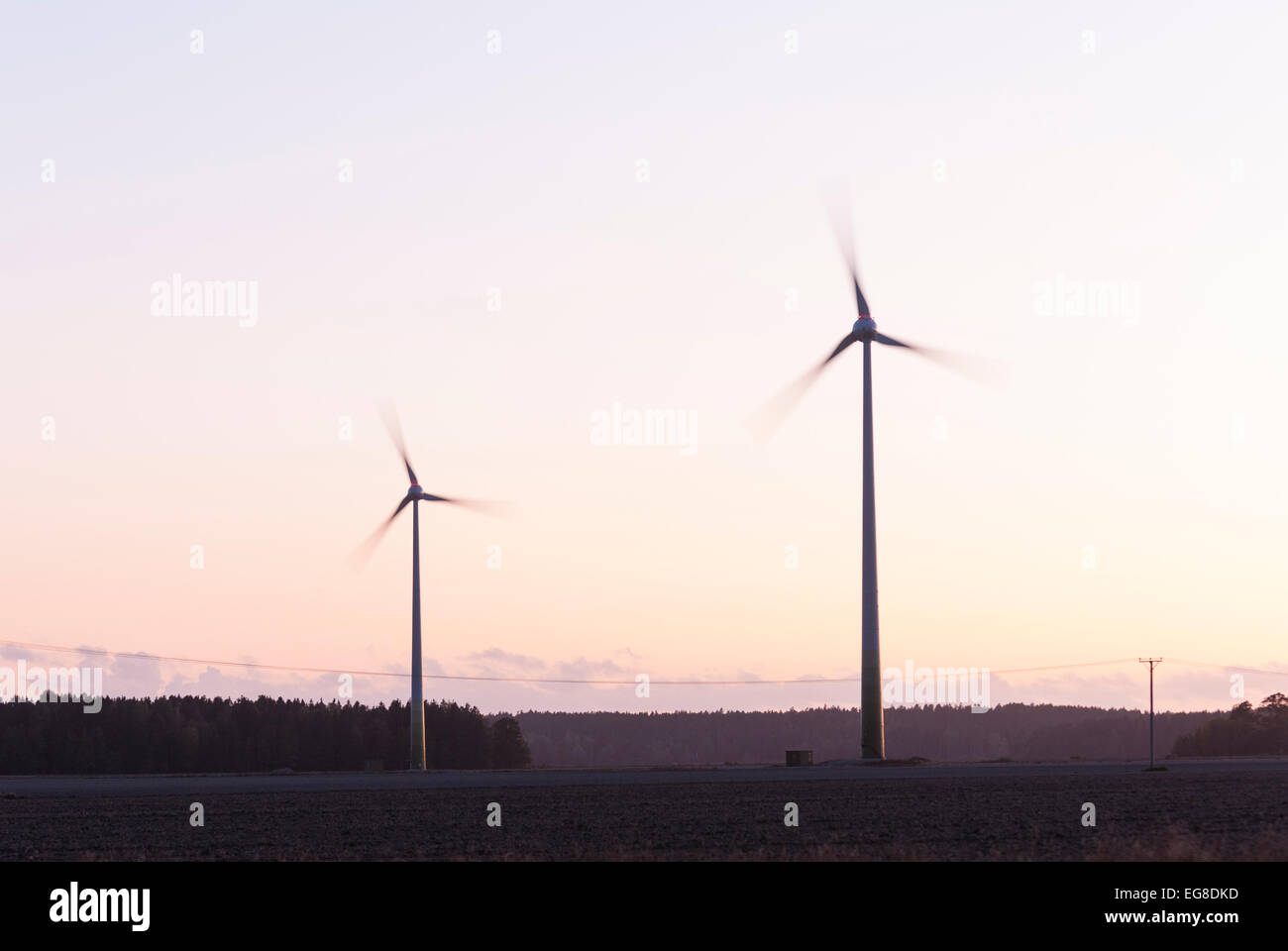 Wind turbines spinning and generating wind-power on an evening in ...