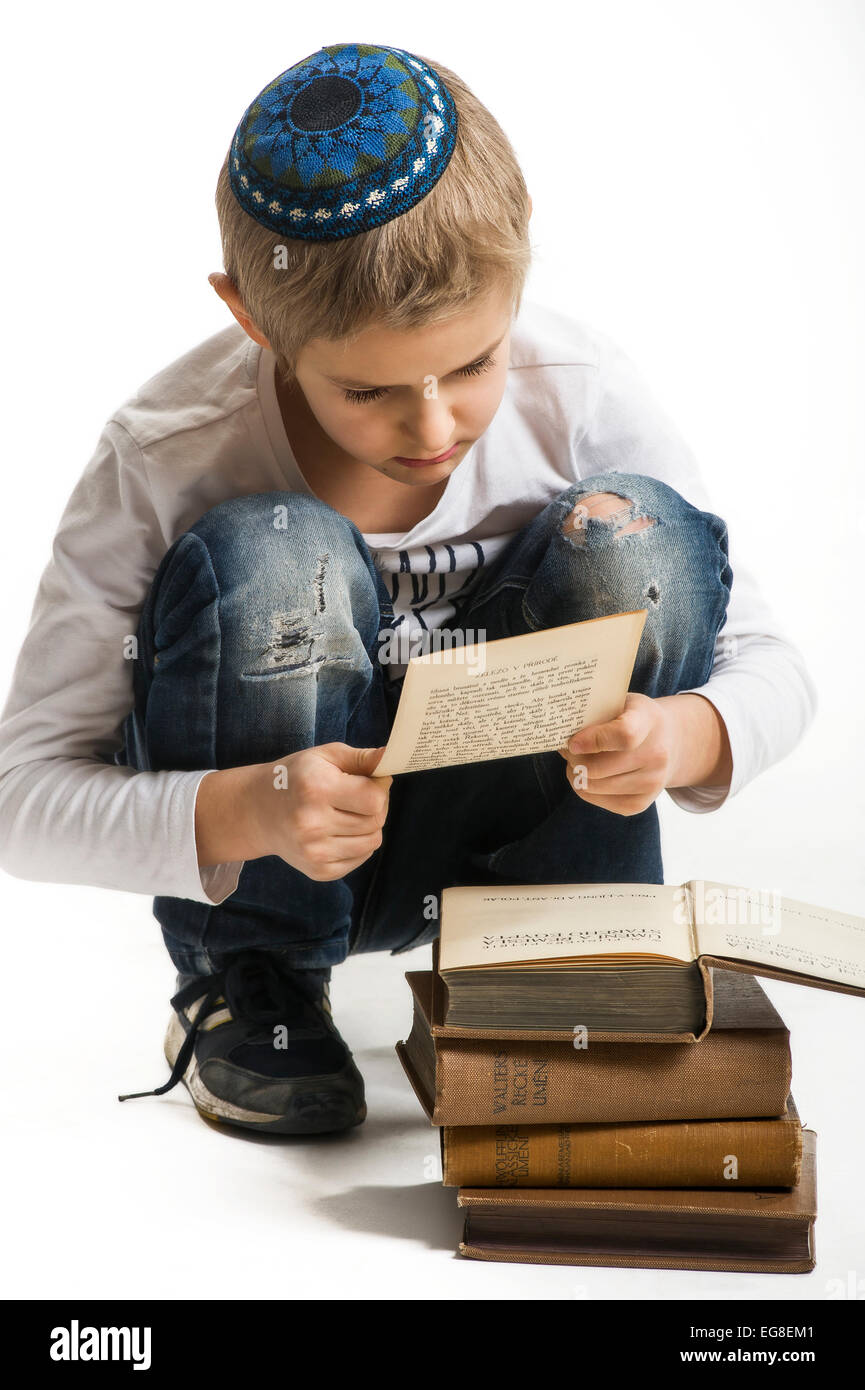 studio portrait of white boy with Jewish kipa or yarmulke and books ...