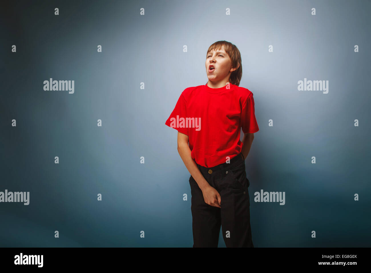 boy teenager European appearance in a red shirt holding his hand over ...