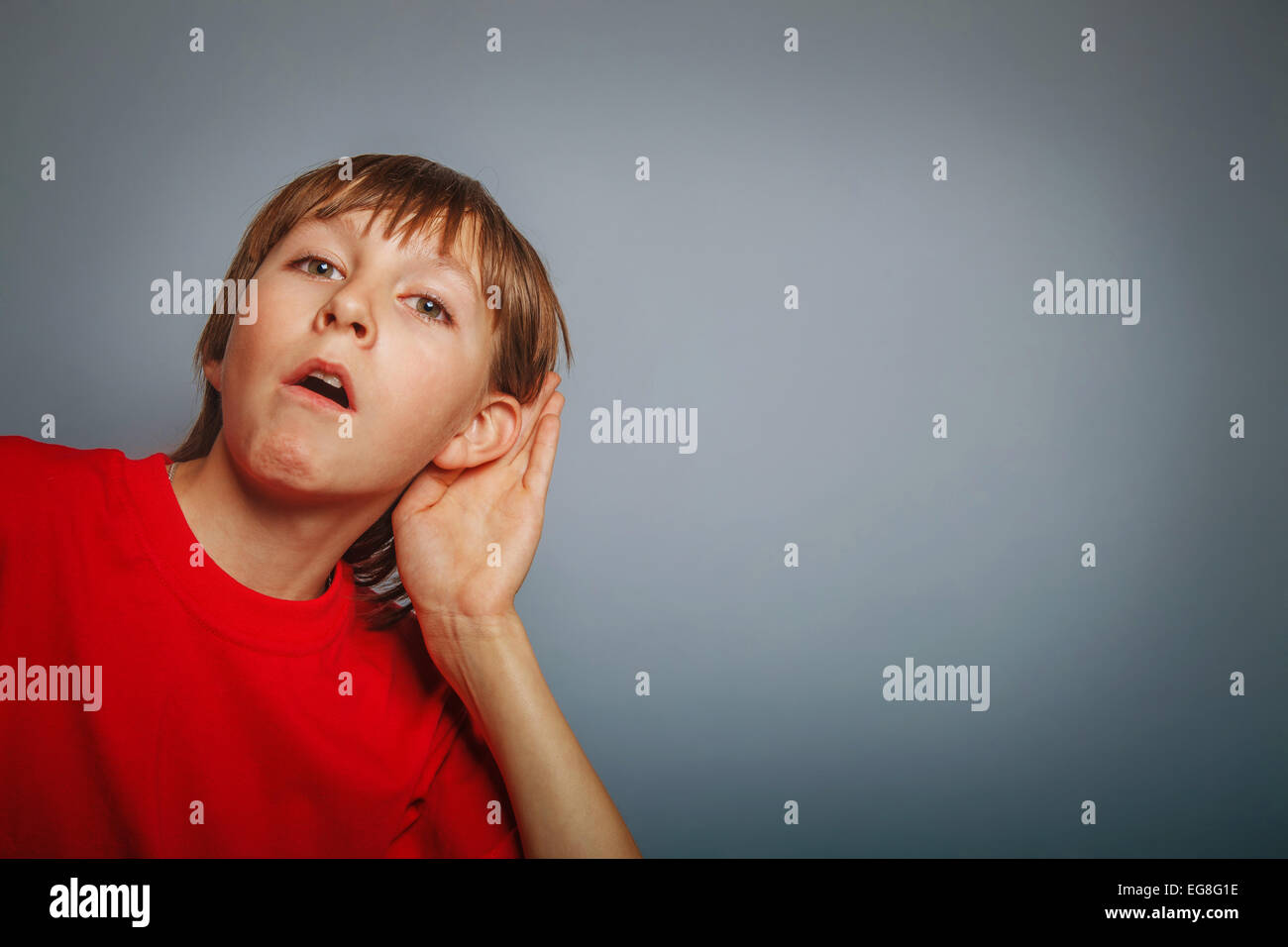 European appearance boy overhears a decade, interest, ear on gray ...