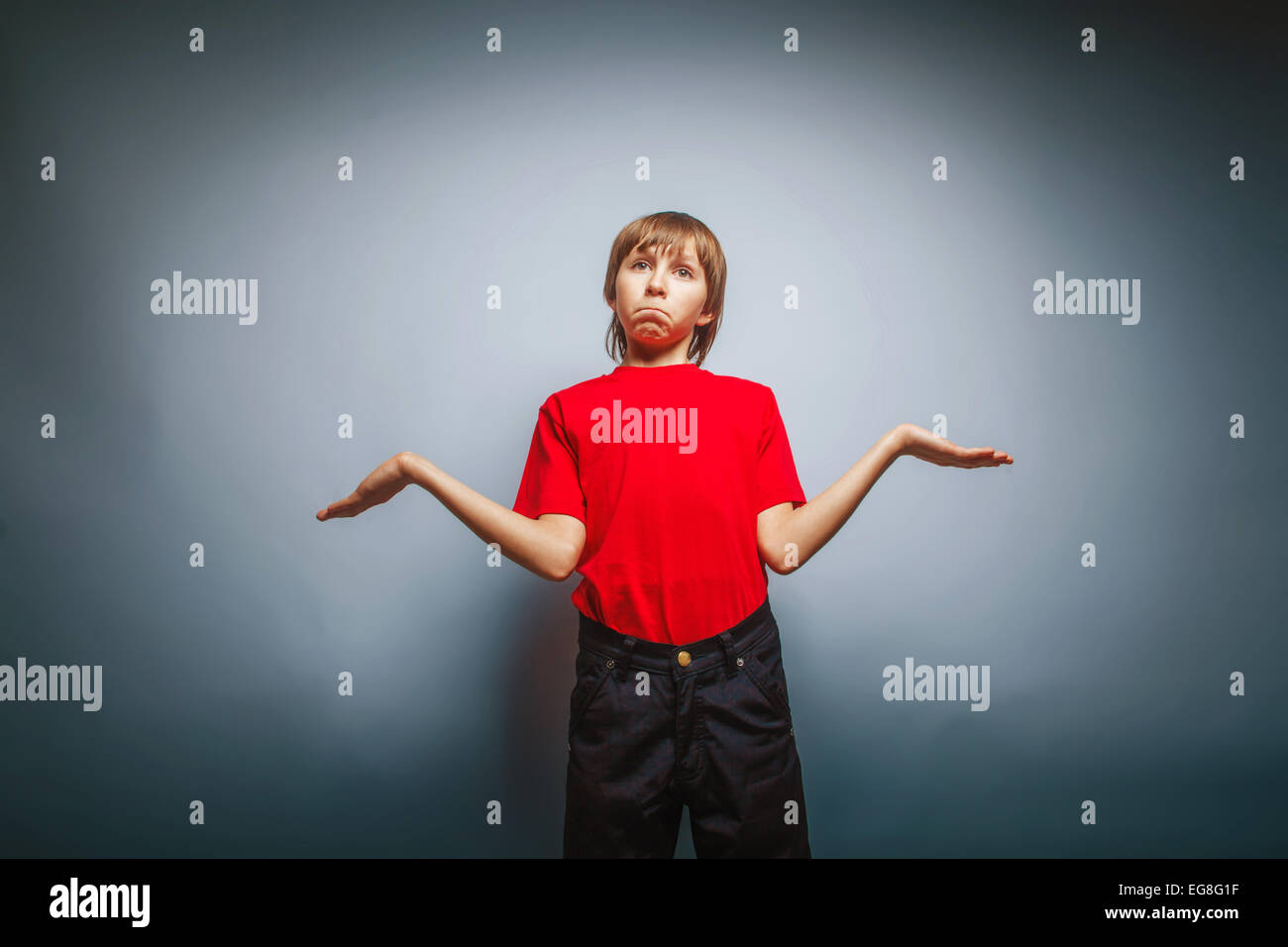 boy teenager European appearance in a red shirt spread his arms on a ...