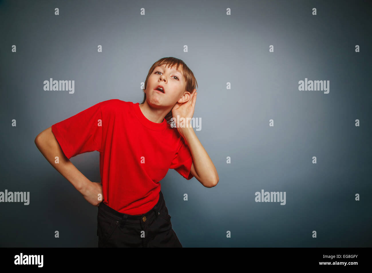 European appearance boy overhears a decade, interest, ear on gray ...