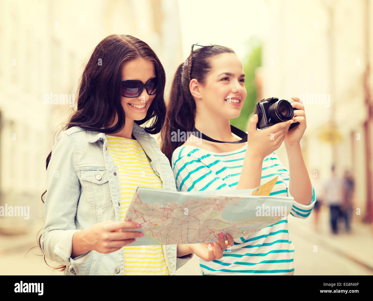 smiling teenage girls with map Stock Photo - Alamy