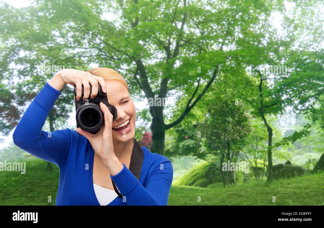 smiling woman taking picture with digital camera Stock Photo - Alamy
