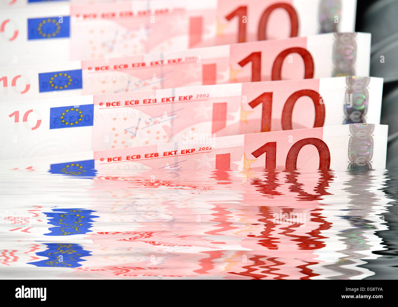 10 euro notes falling into a digitally created pool of water Stock ...
