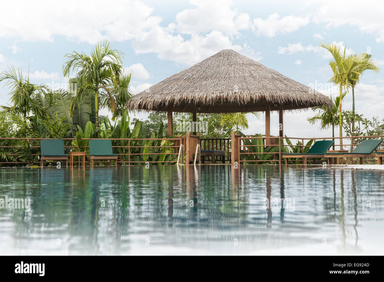 view of nice tropical pool with exotic hut on the back Stock Photo - Alamy