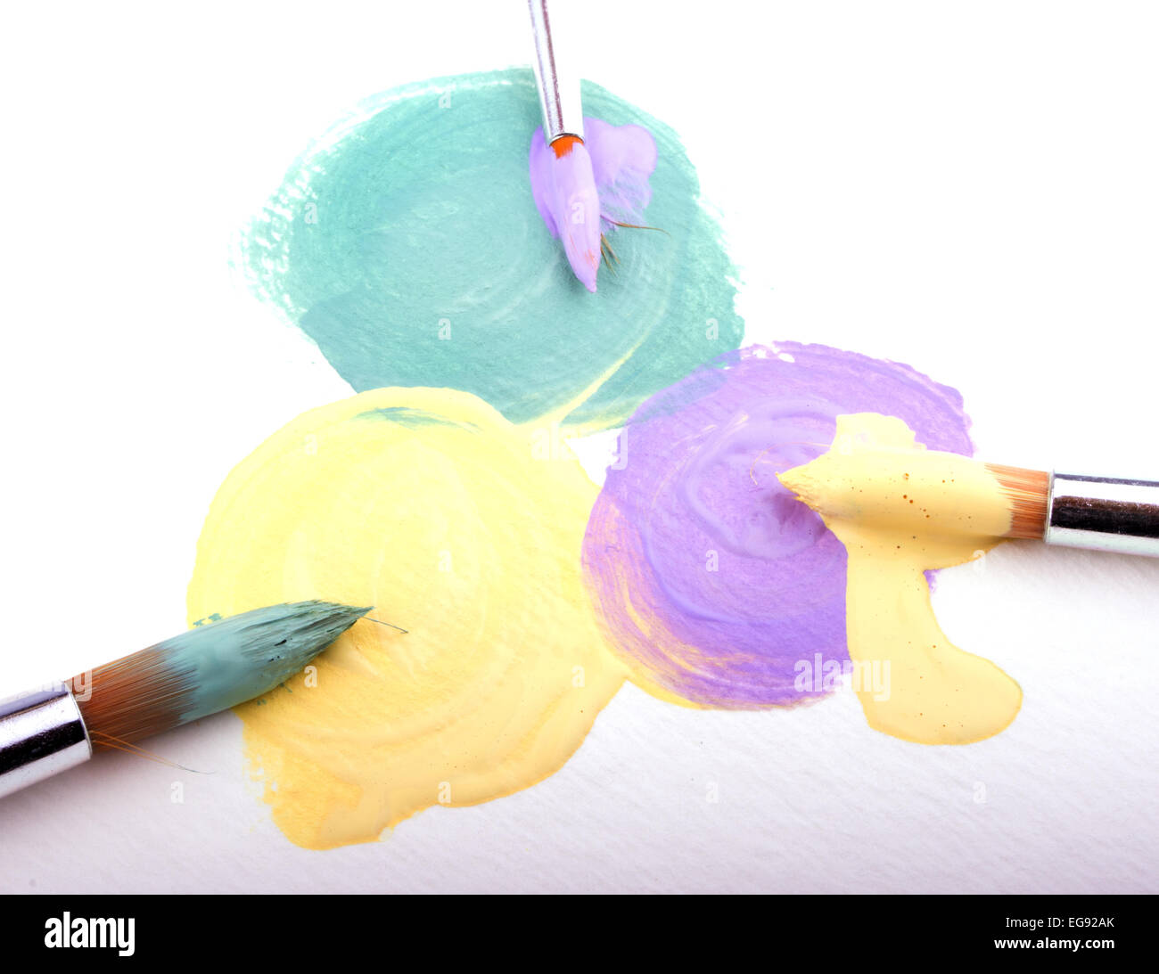 Green, yellow and lilac spots of paint on white textured paper, with ...