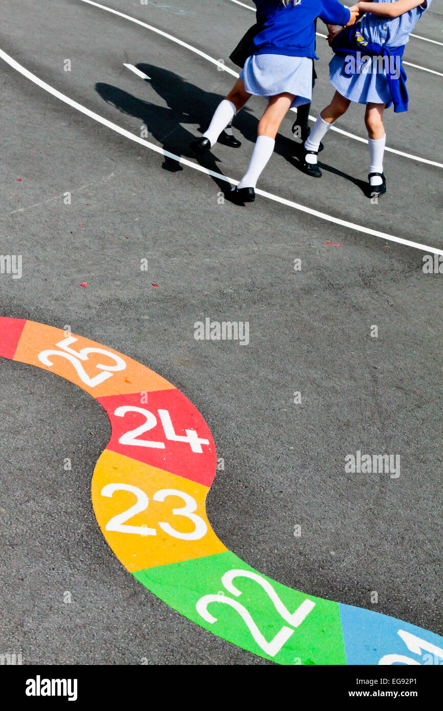 Primary schoolchildren playing in a school playground at break time ...