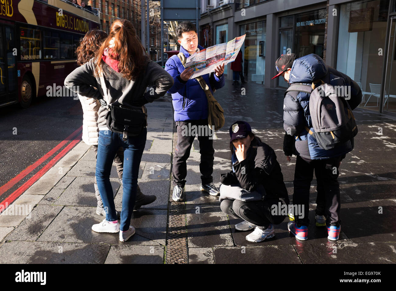 Chinese tourists stop to look at a map while trying to find their way ...