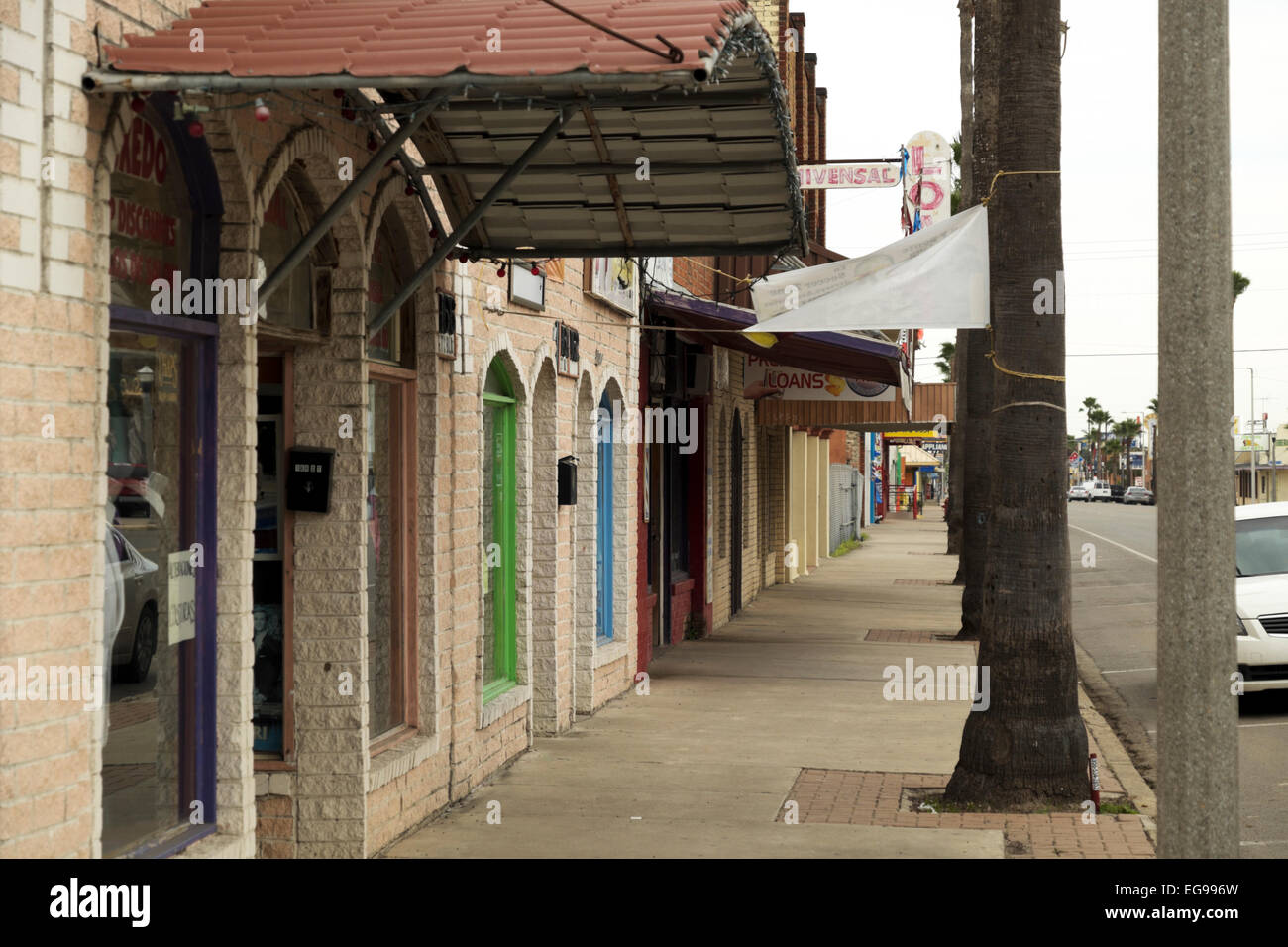 Sidewalk scene showing various colorful storefronts in downtown Weslaco ...