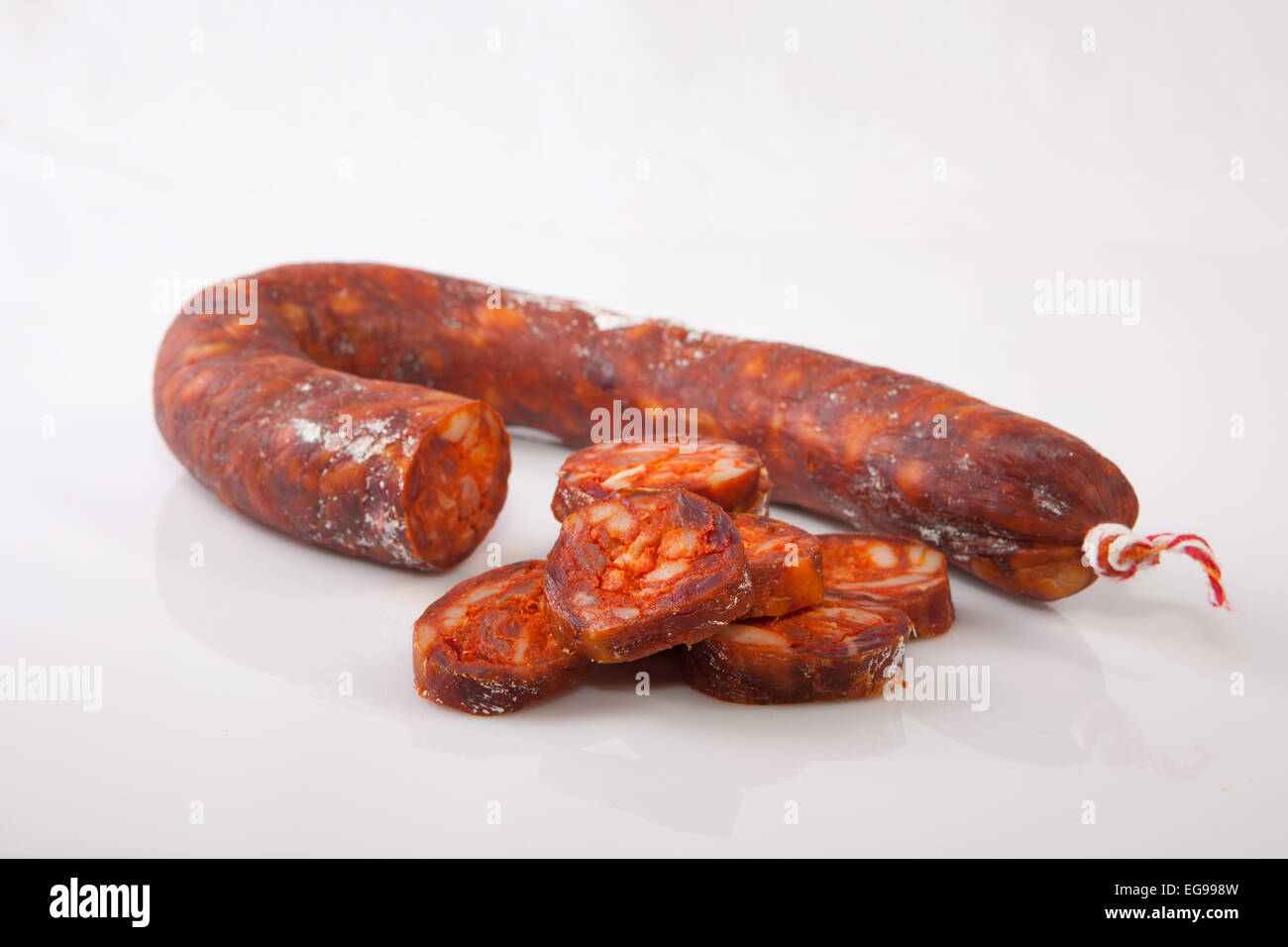 Red iberian chorizo with some cut pieces. Isolated over white ...