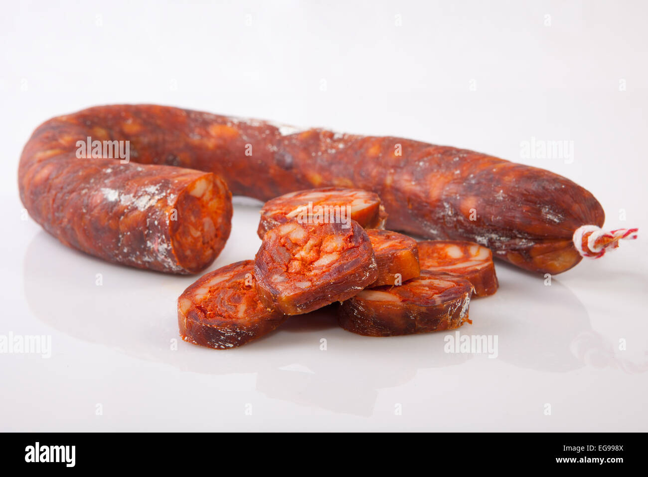 Red iberian chorizo with some cut pieces. Isolated over white ...