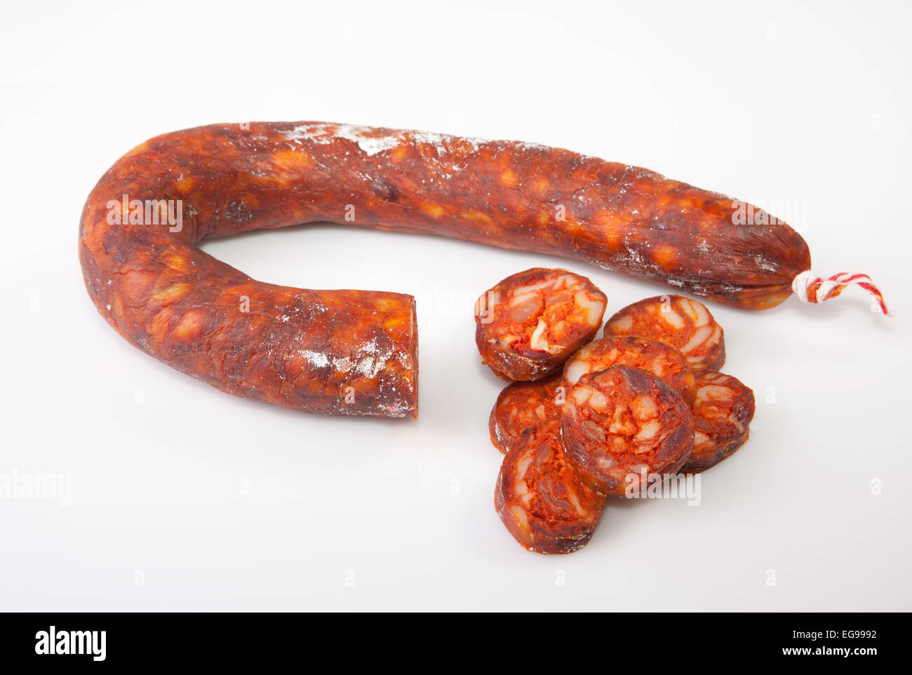 Red iberian chorizo with some cut pieces. Isolated over white ...